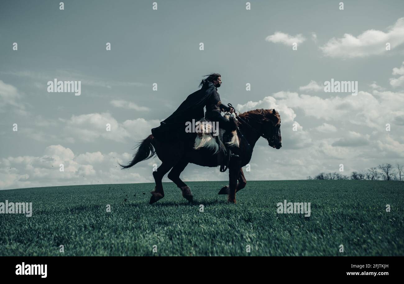 Woman in chain mail in image of medieval warrior rides on galloping ...