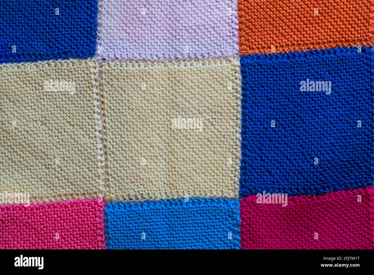 knitted squares sewn together to make a blanket, close up detail of ...