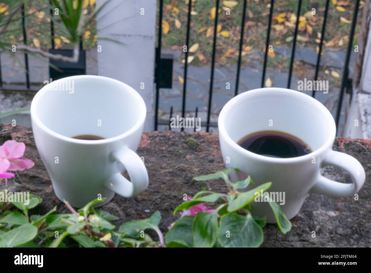Two empty coffee cups on a balcony ledge Stock Photo - Alamy