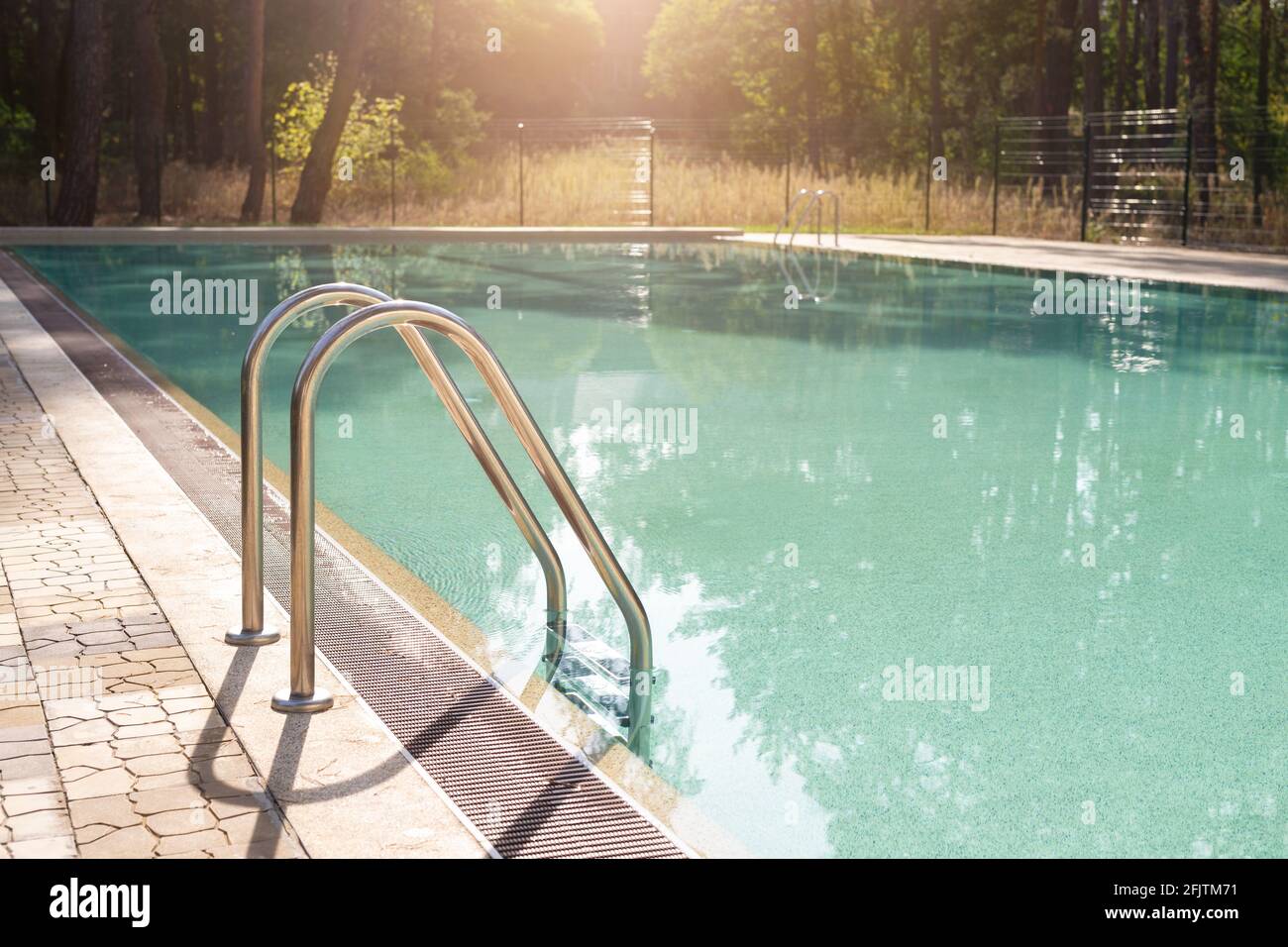 Big luxury empty rectangular swimming pool with clean blue water and ...