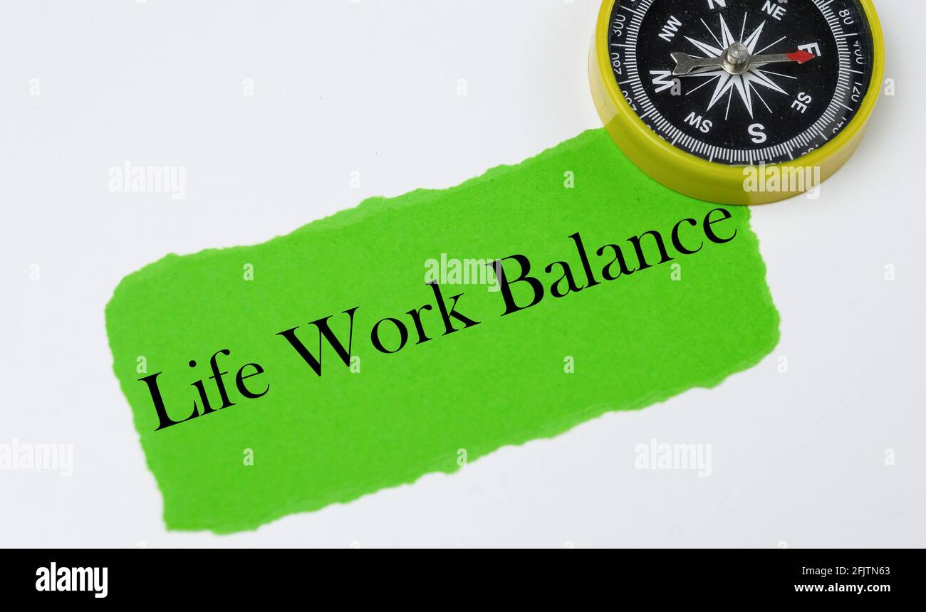 Life work balance written on a green torn paper with compass Stock ...