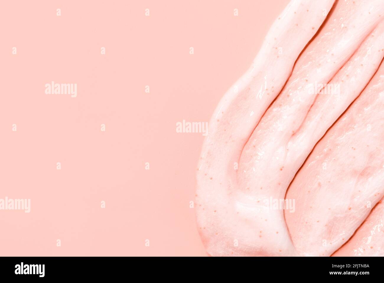 The texture of a scrub or shower gel on a pink background. Copy spase ...