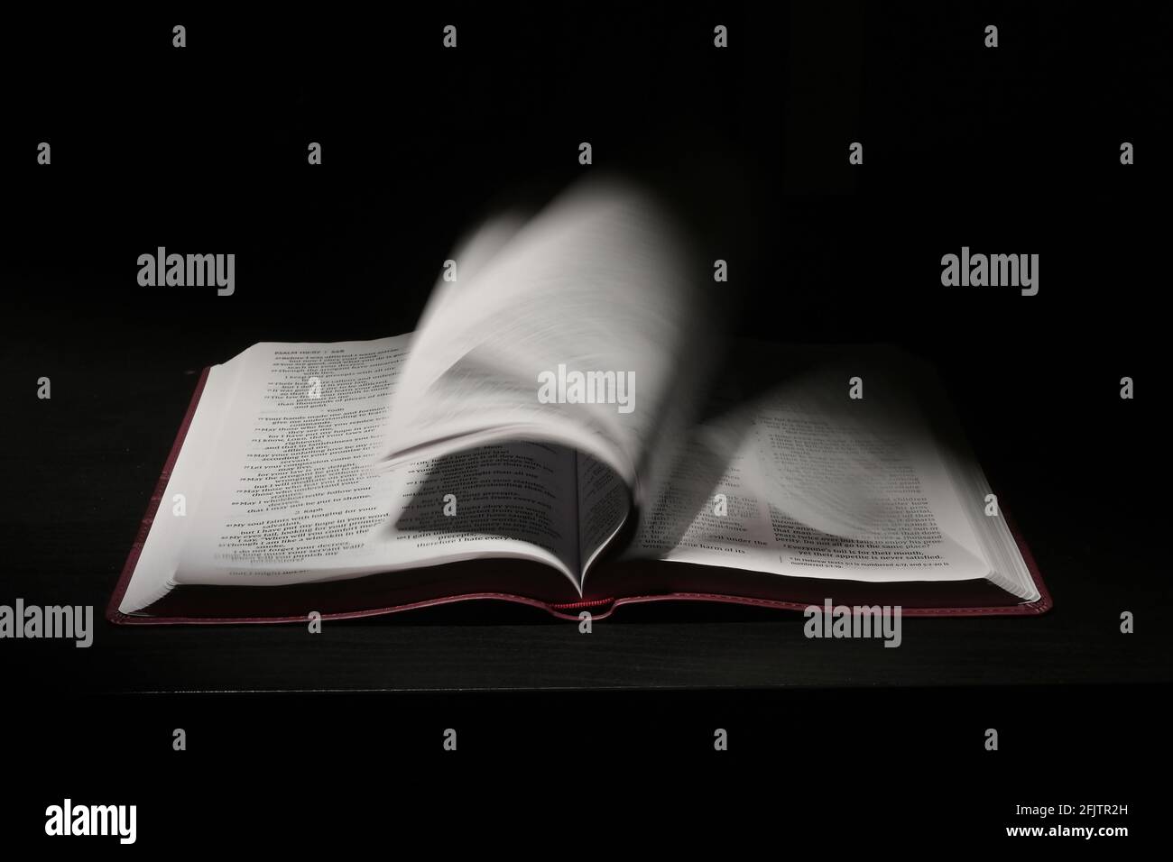 An Open Holy Bible Moving Pages on Dark Bckground Stock Photo - Alamy