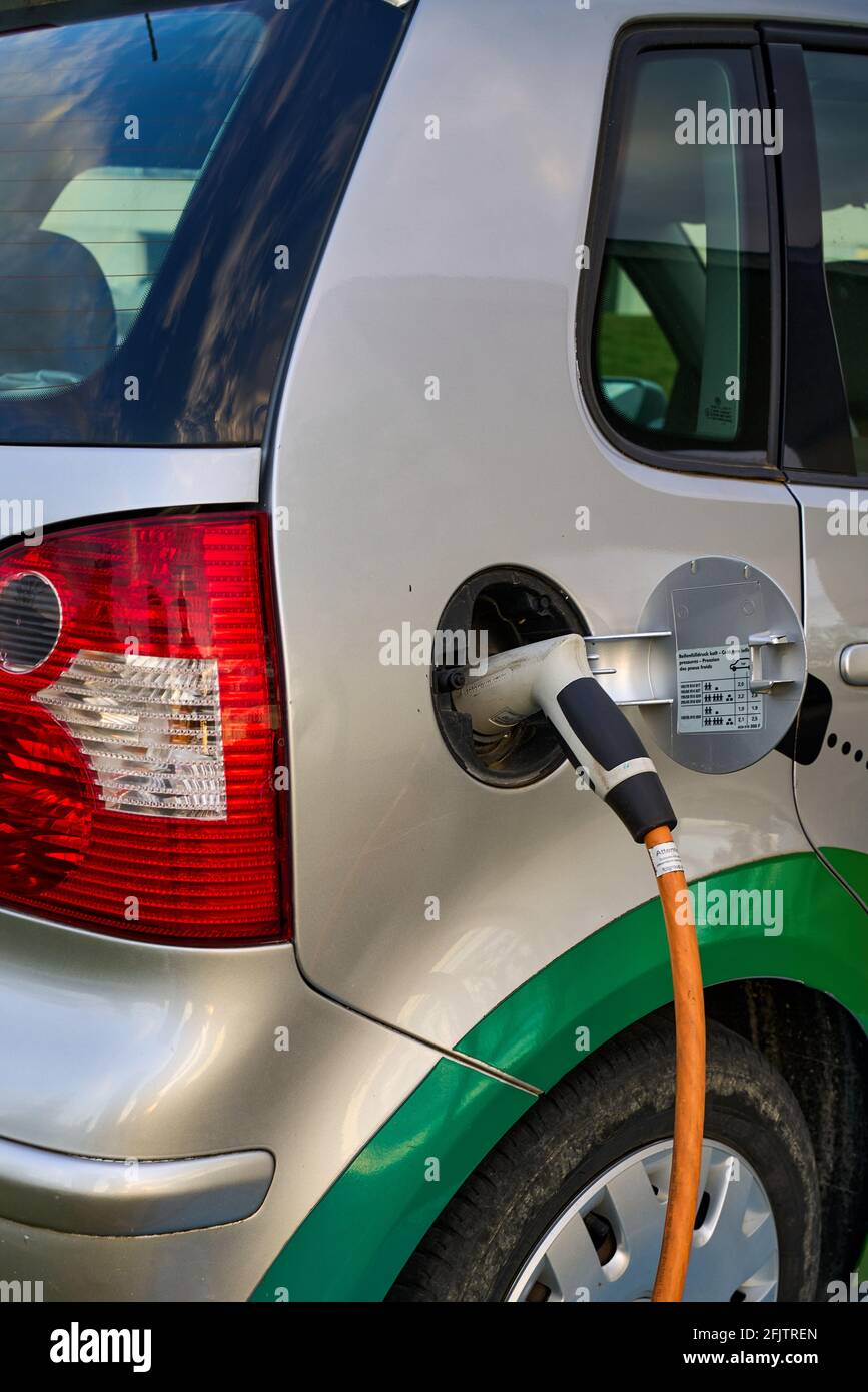 Electric car in full charge connected to electric point Stock Photo - Alamy