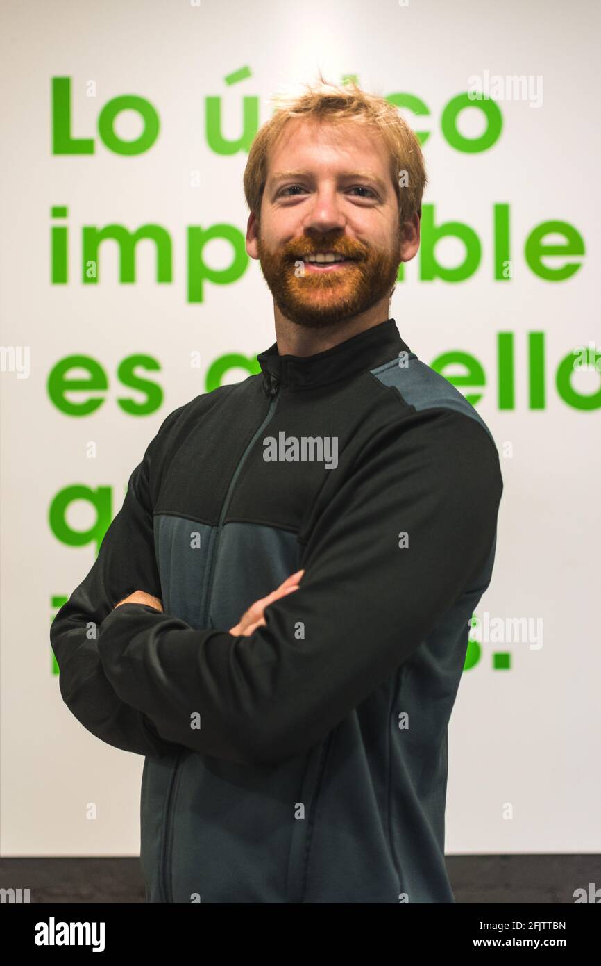 Portrait of smiling red-haired male personal trainer in a black ...