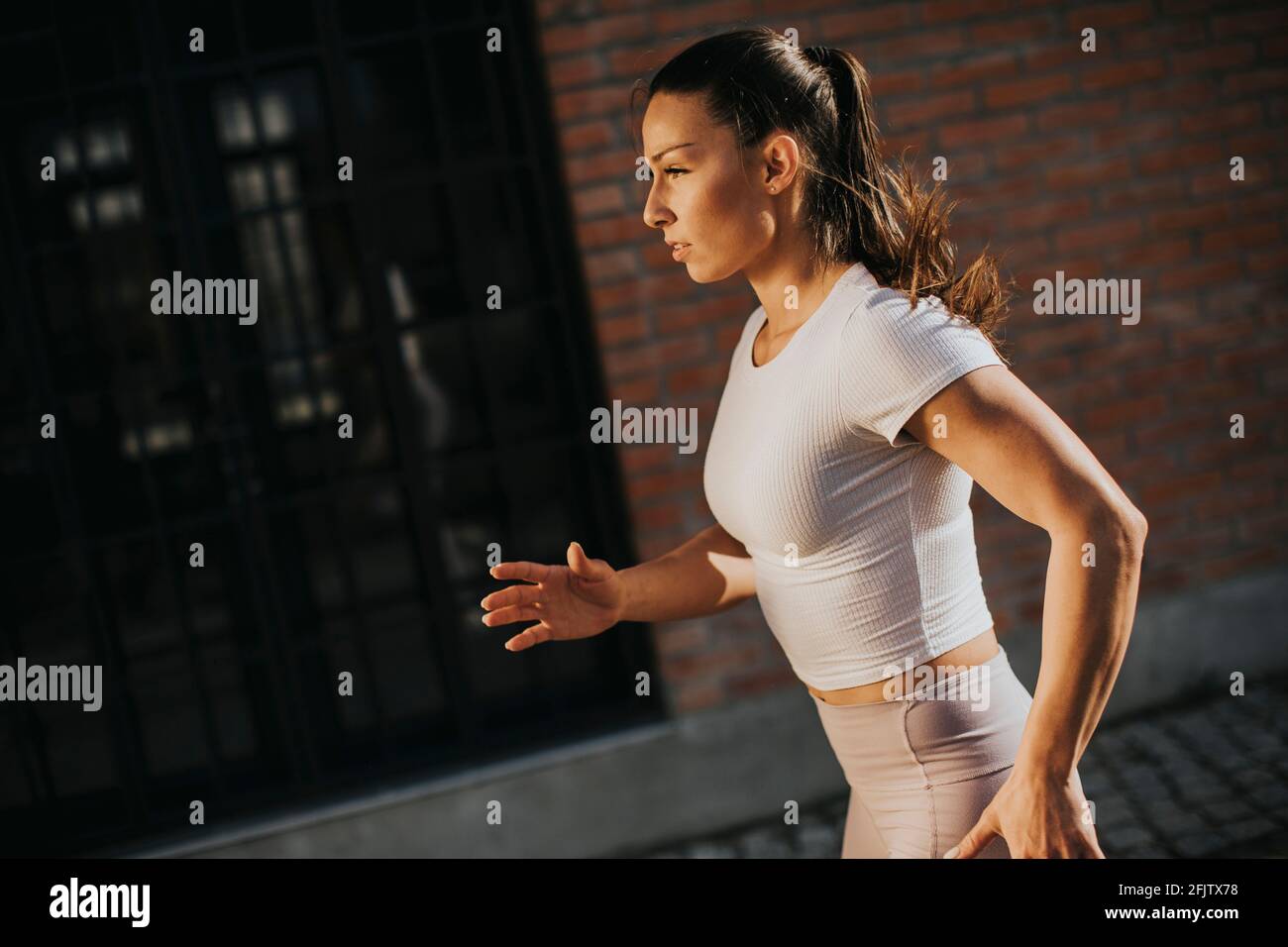 Pretty young woman running on the street Stock Photo - Alamy