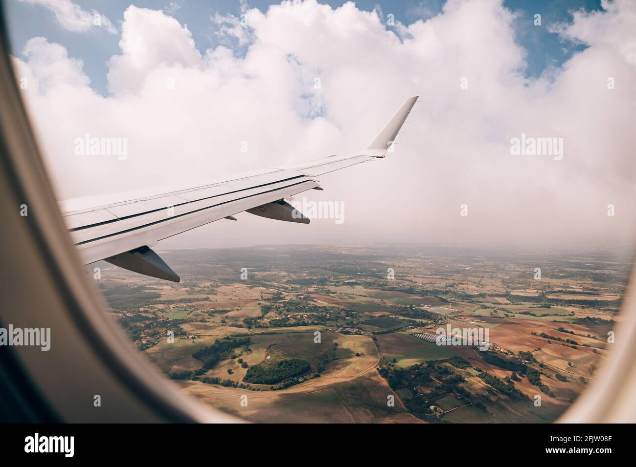 View from the airplane window of the fields and greenery below through ...