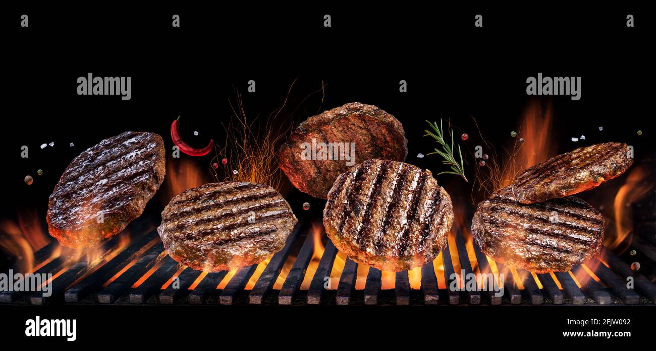 Grilled beef steaks in motion falling down on open grill. Conceptual ...