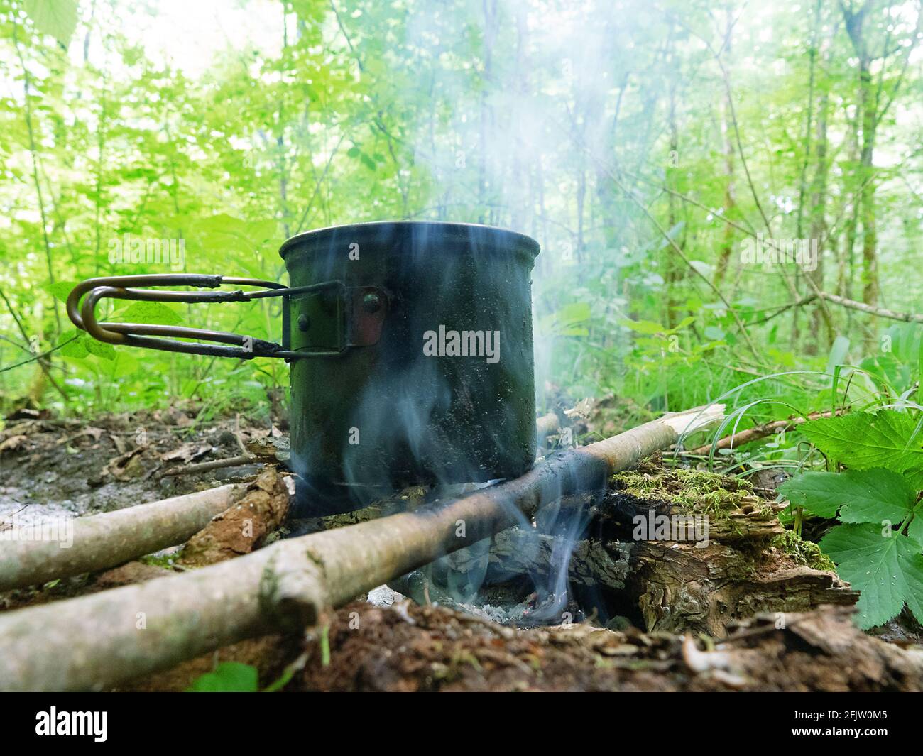 Field kitchen. Cooking on fire during hike. Pot hanging over fire Stock ...