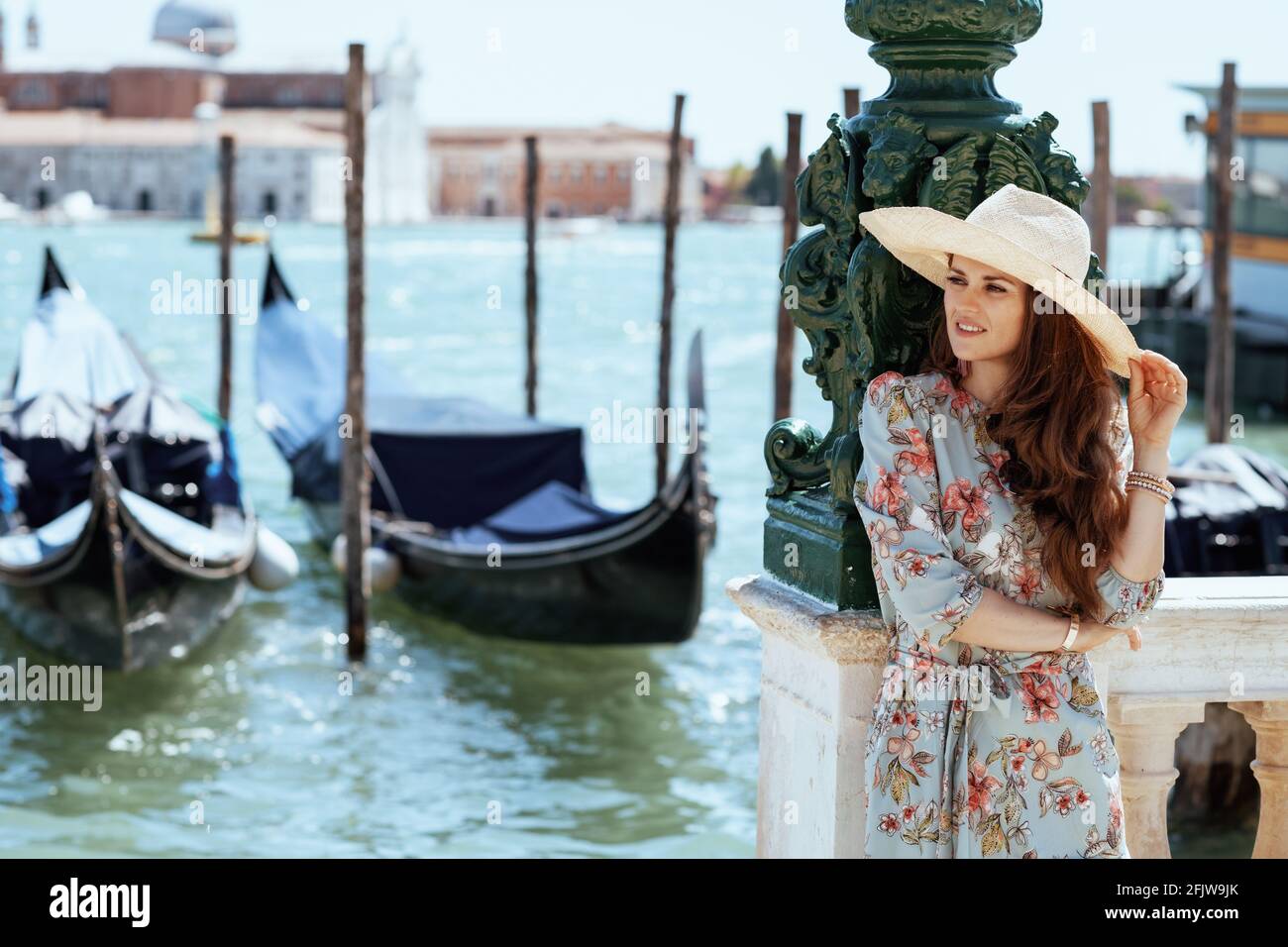 relaxed stylish traveller woman in floral dress with hat exploring ...