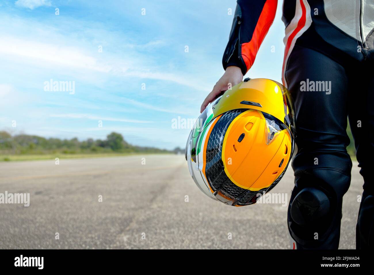 rider motorbike holding his motorcycle helmet walking in the road ...
