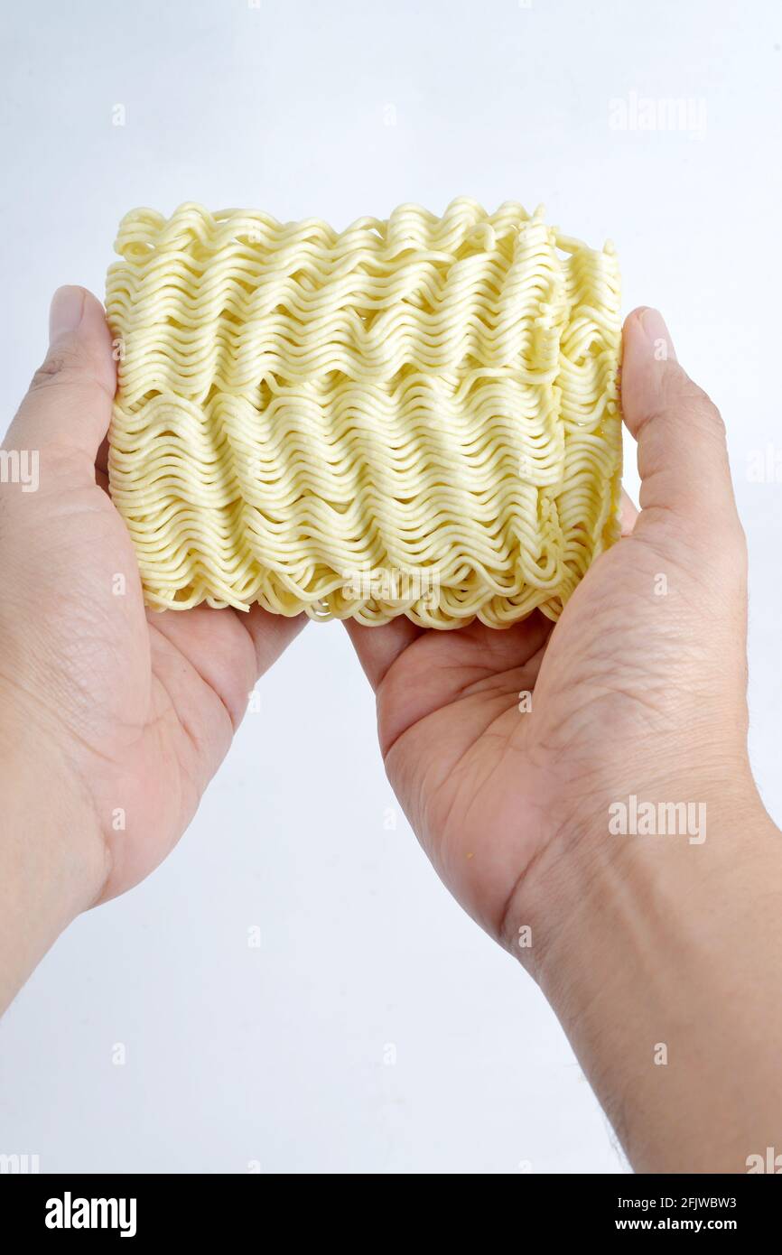 hand holding raw instant noodles, white background Stock Photo - Alamy