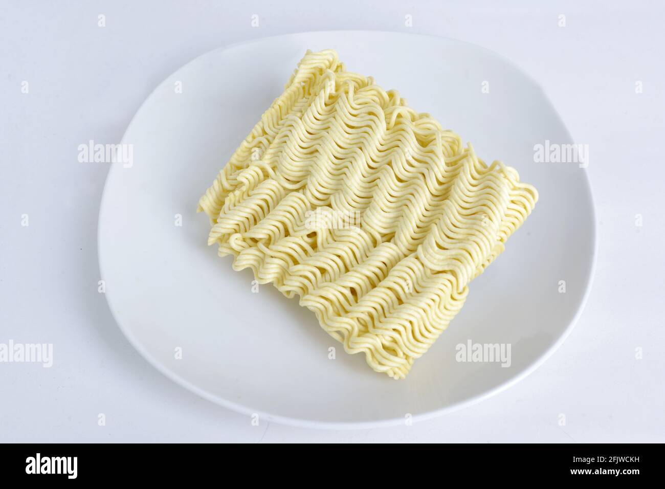 raw noodle in a white plate, isolated white background Stock Photo - Alamy