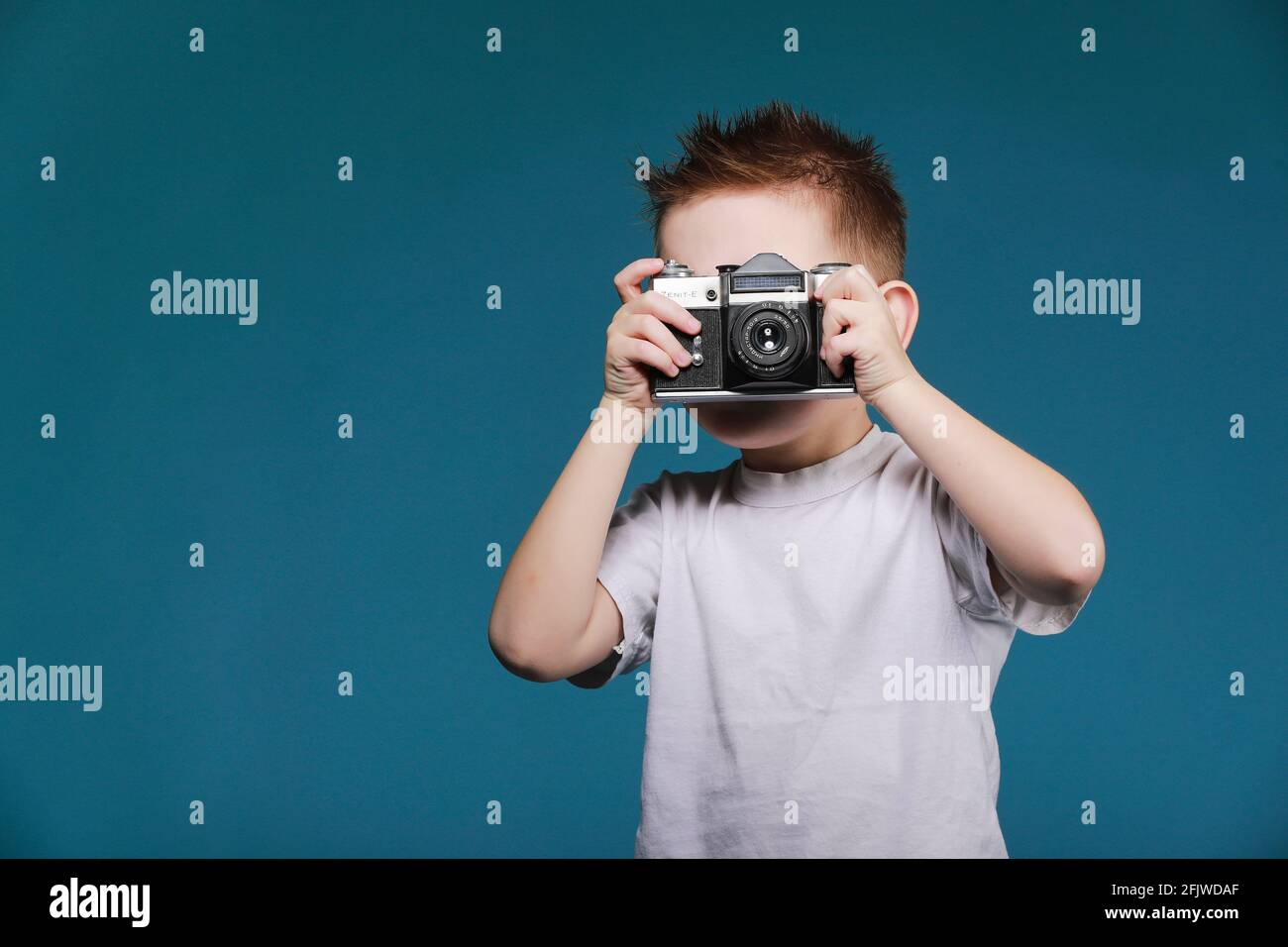 Little boy taking a picture using a retro camera. Child boy with ...