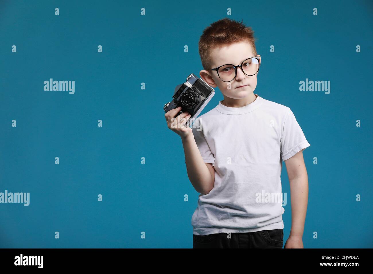 Little boy taking a picture using a retro camera. Child boy with ...