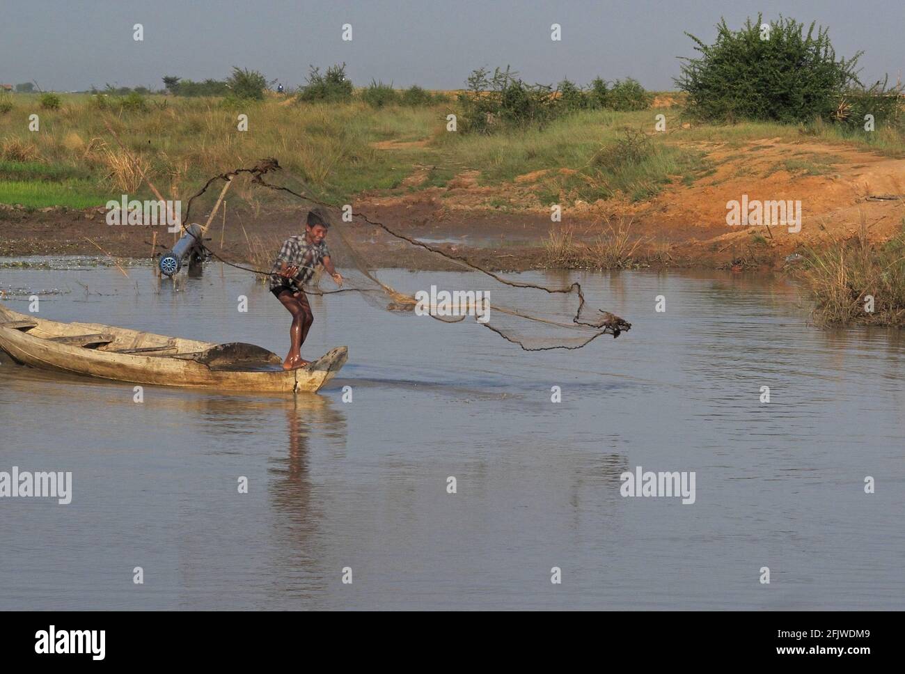 boy throwing fishing net from boat Cambodia January Stock Photo - Alamy