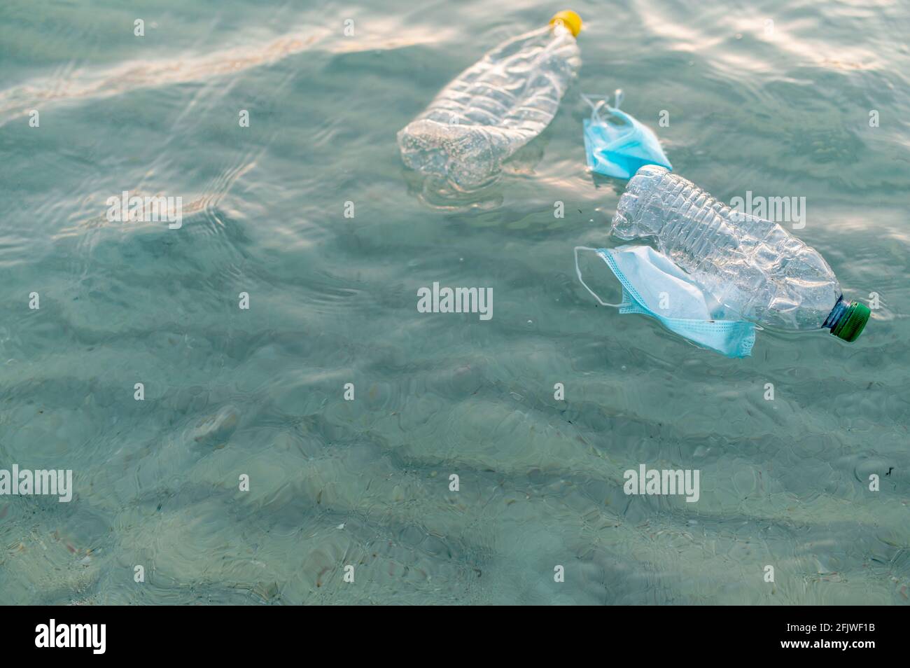 Garbage floating on sea or ocean water with plastic bottles and face ...
