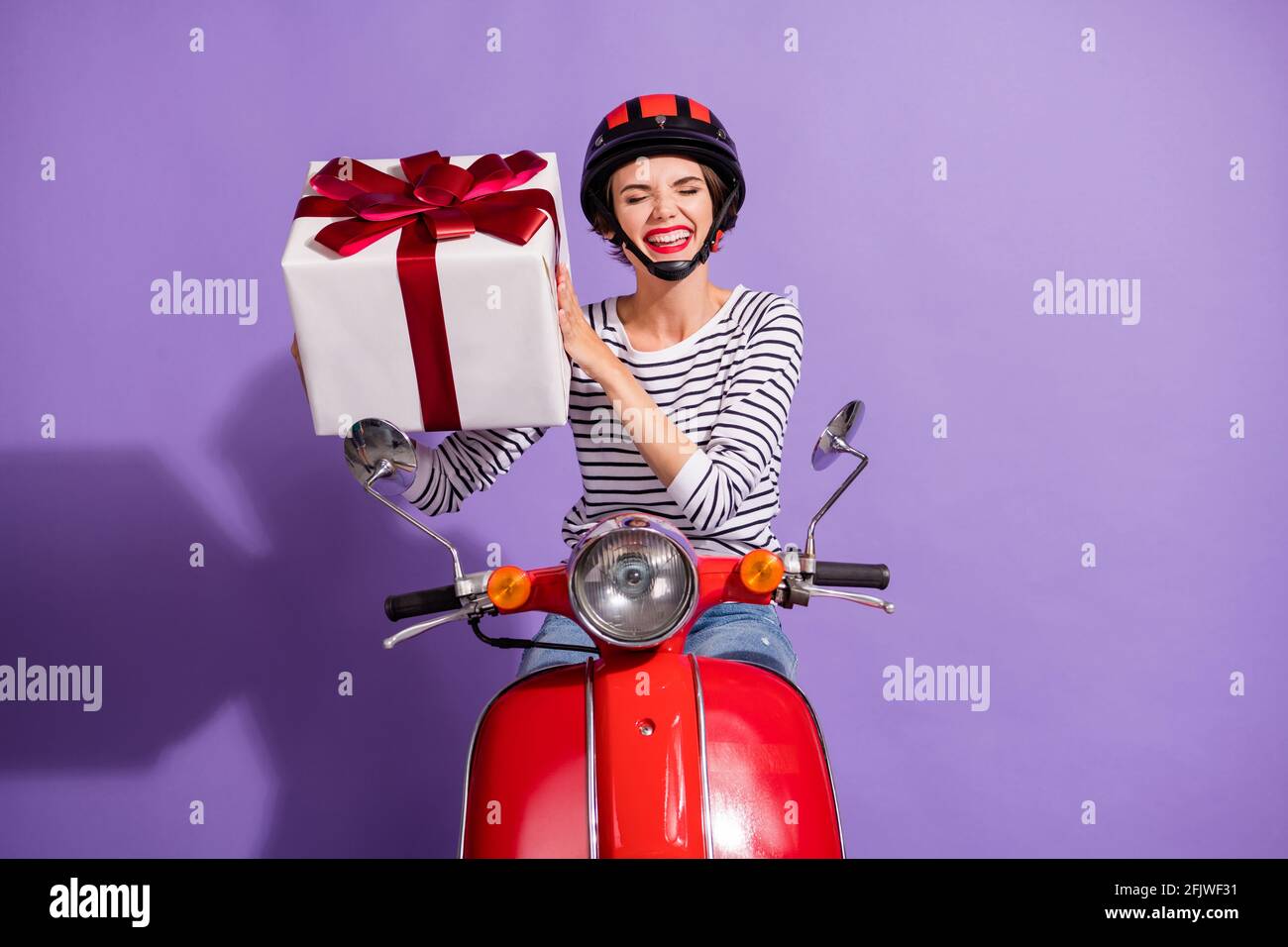 Portrait photo of girl on scooter trying to guess what inside wrapped ...