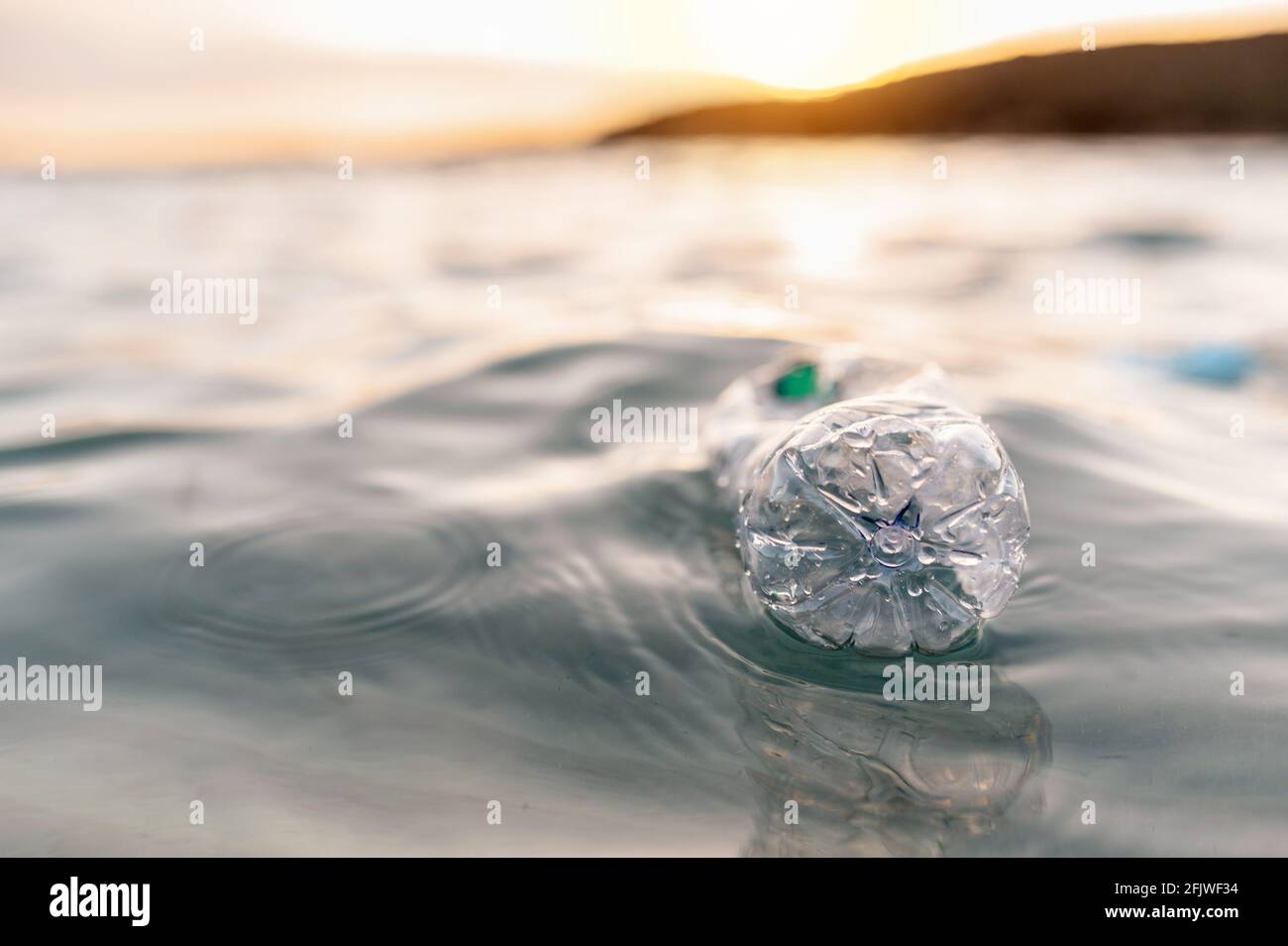 Garbage floating on sea or ocean water with plastic bottles and face ...