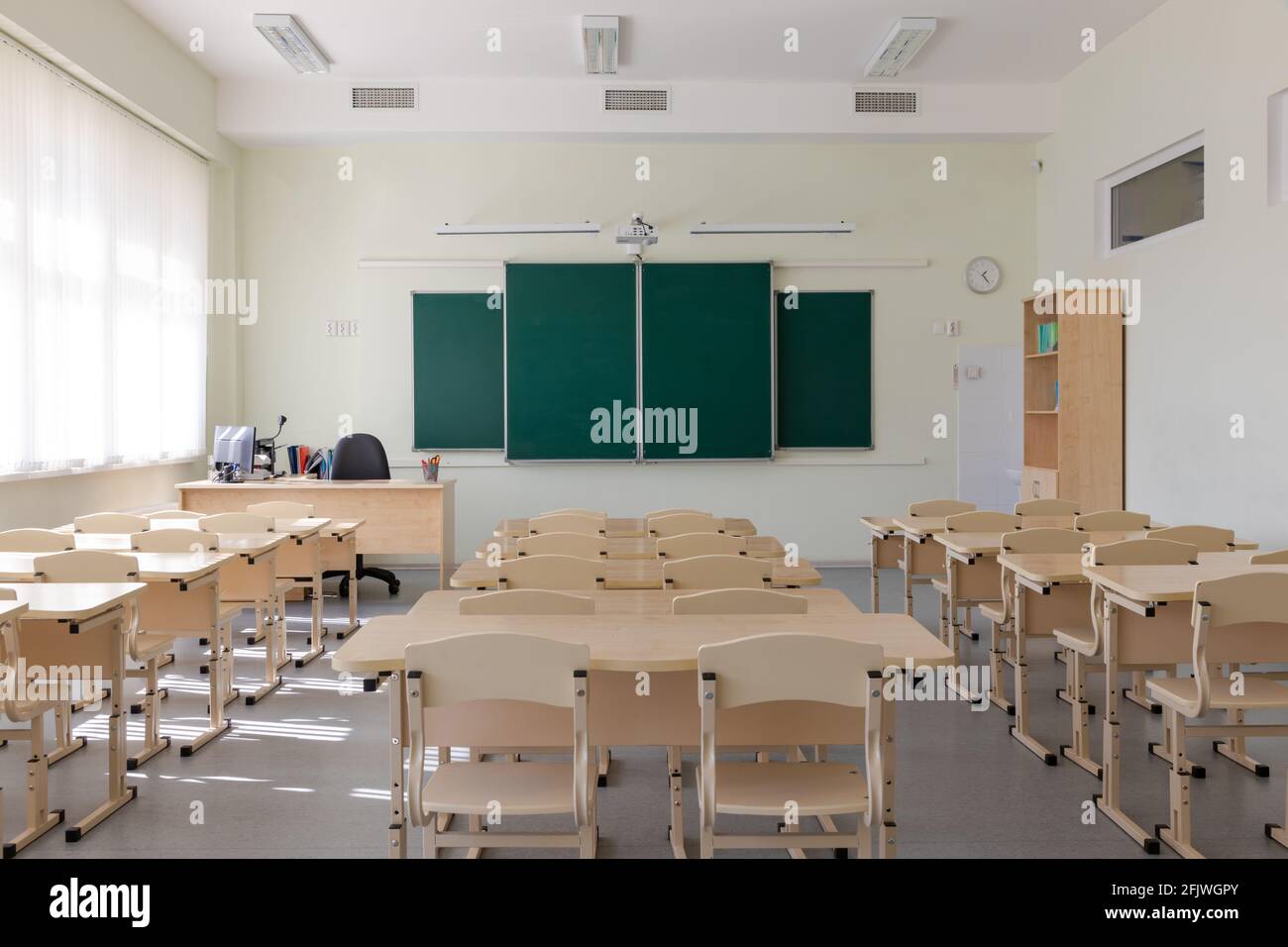 empty school class before final exams. desks and chairs are neatly ...