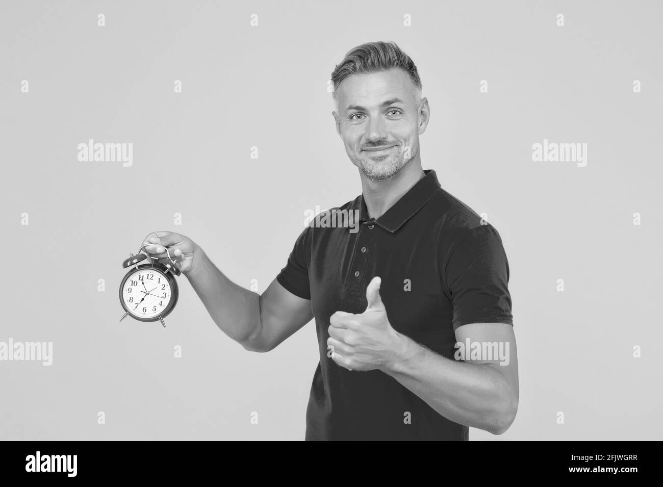 He is always punctual. Punctual man hold alarm clock showing thumbs up ...