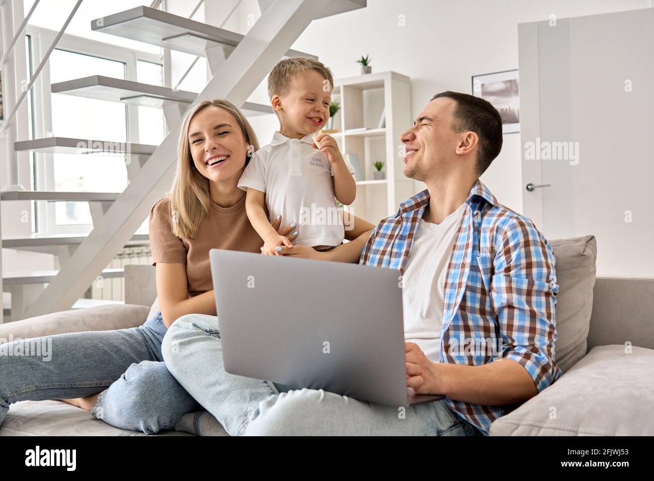 Happy family mom, dad and cute child son having fun using laptop at ...