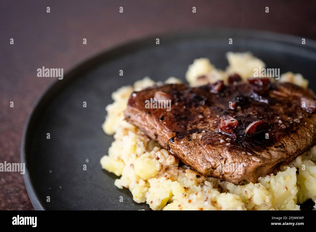 Beef steak with garlic and potato purée with mustard Stock Photo - Alamy