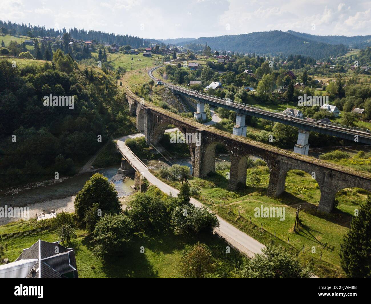 Aerial to old viaduct railway crossing in Vorokhta village, Ukraine ...