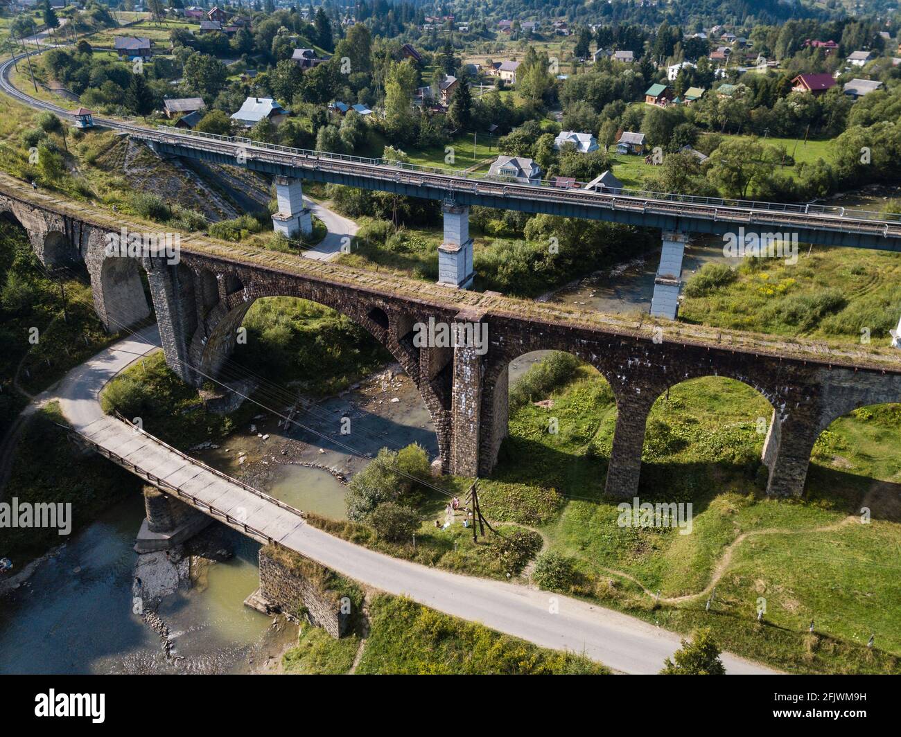 Aerial to old viaduct railway crossing in Vorokhta village, Ukraine Carpathians. River Prut and ...