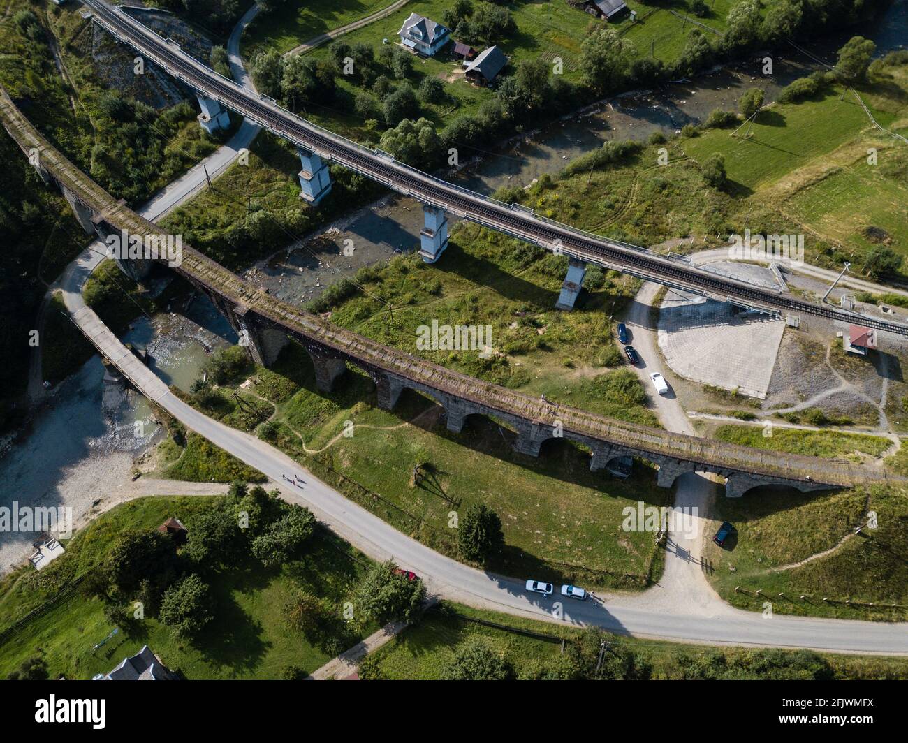 Aerial to old viaduct railway crossing in Vorokhta village, Ukraine Carpathians. River Prut and ...