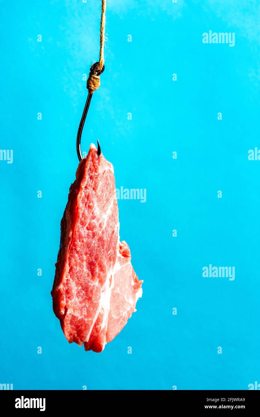 Pork steak on a hook. Bait. Free profit. Dangerous gain Stock Photo - Alamy