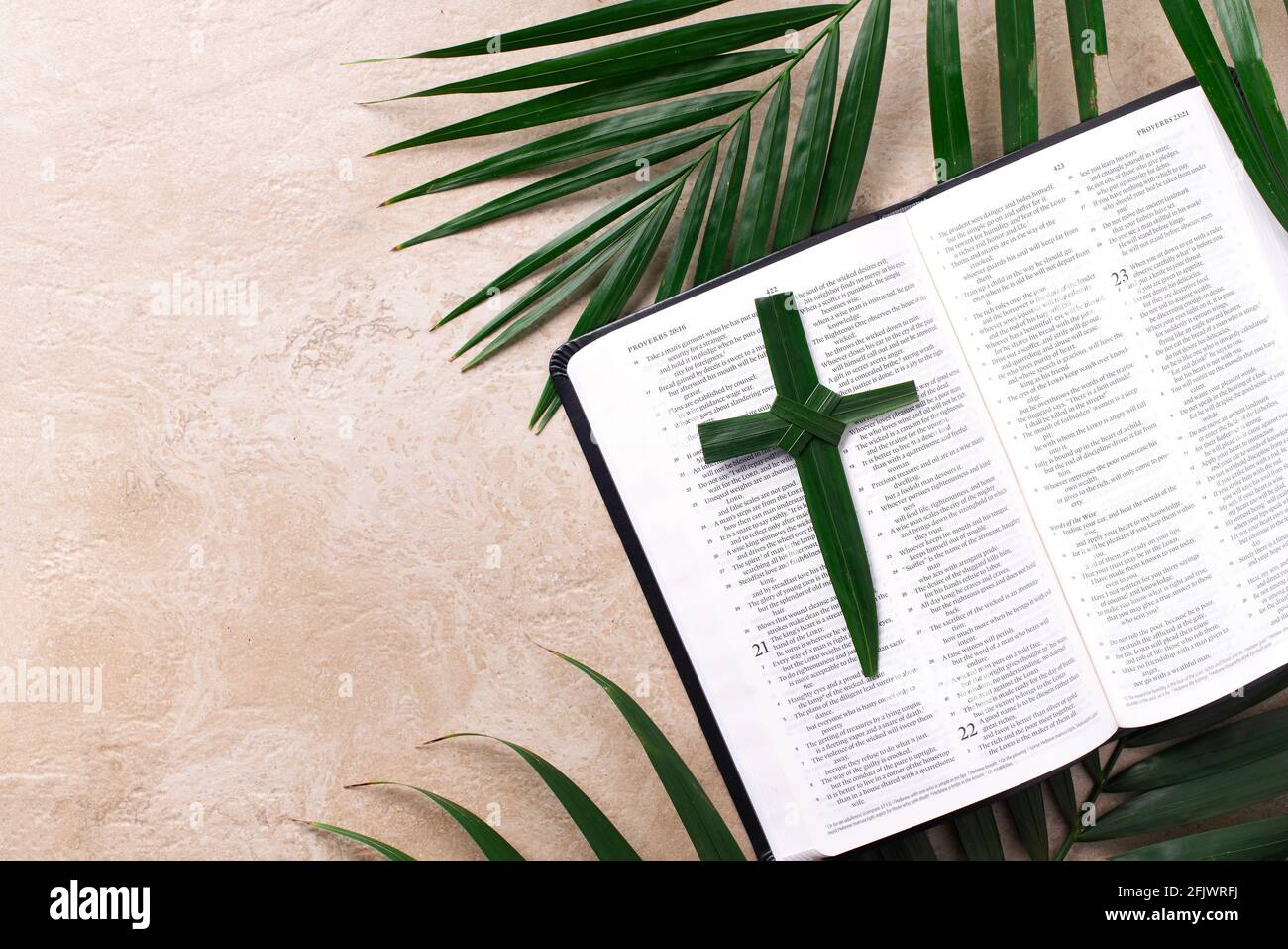 Palm Sunday concept. Palm cross on open Holy Bible and palm leaves ...