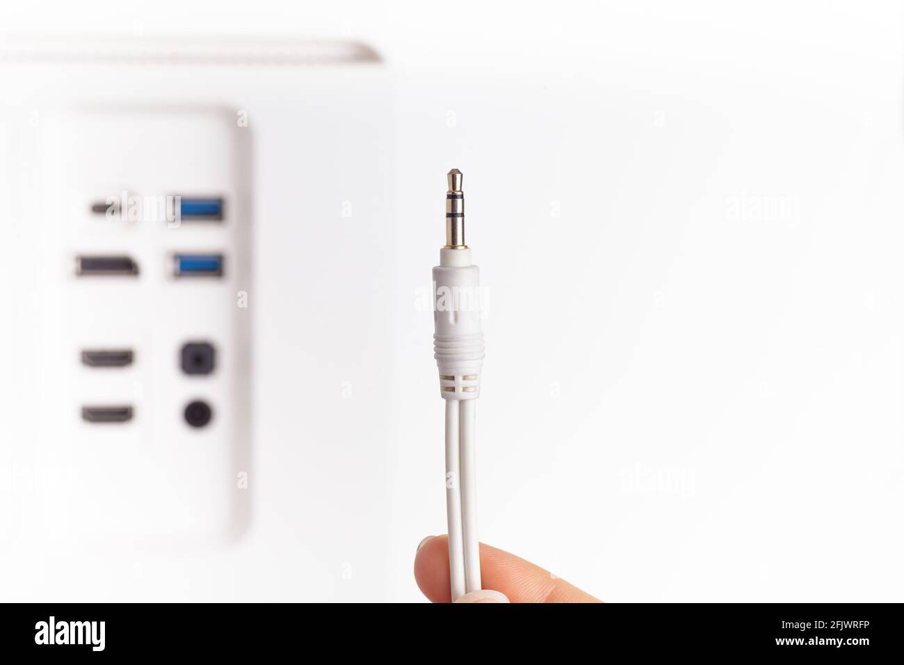 Close-up of the jack 3.5 cable in a hand. The monitor's built-in USB ...