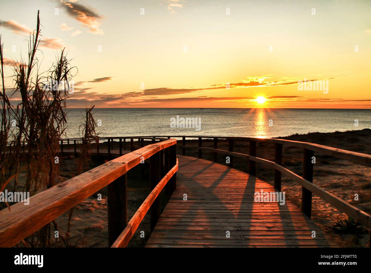 Wooden walkway to Arenales del Sol beach in a beautiful with sunrise ...