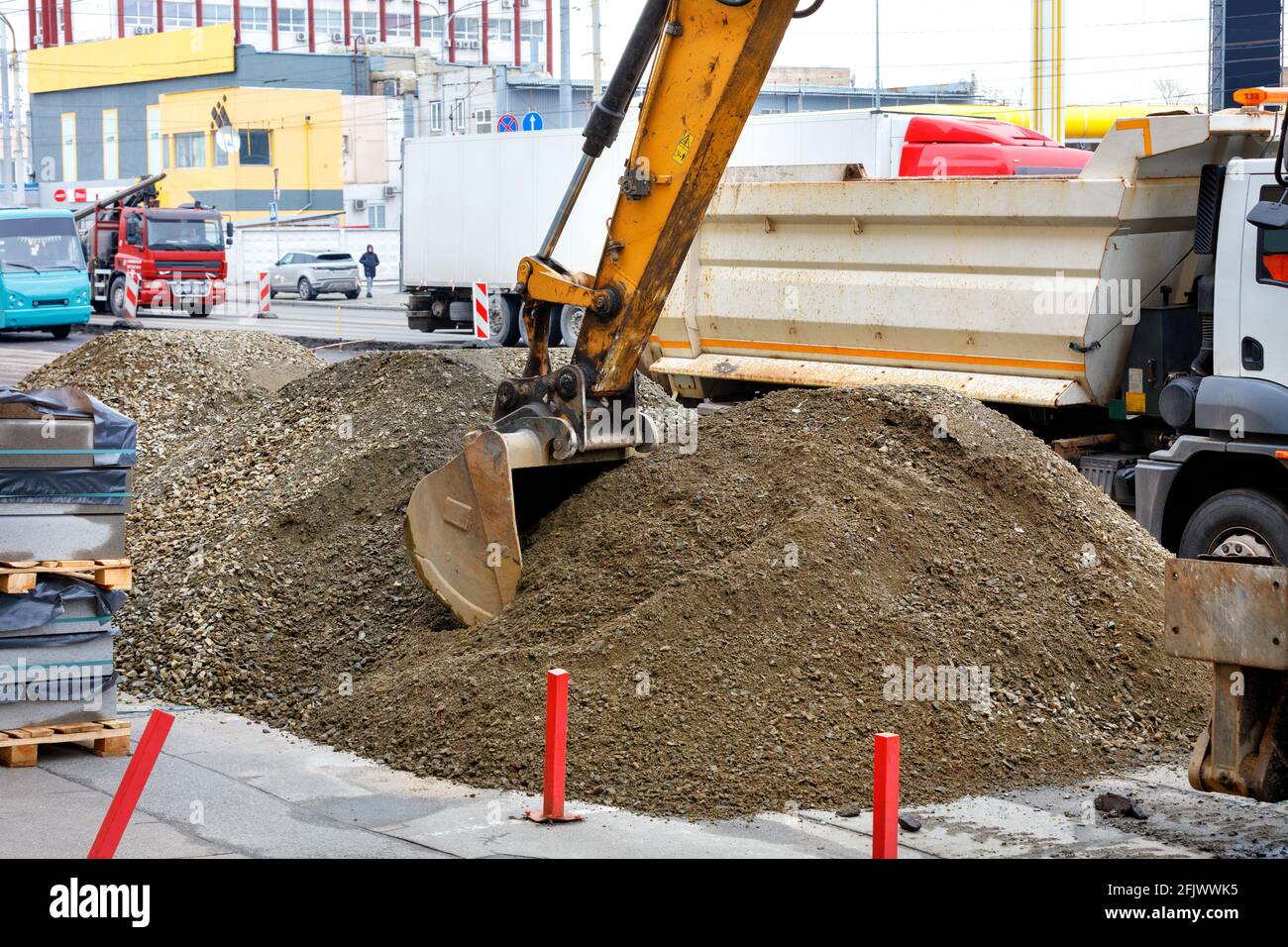 A road excavator bucket works on loading crushed stone and sand into ...