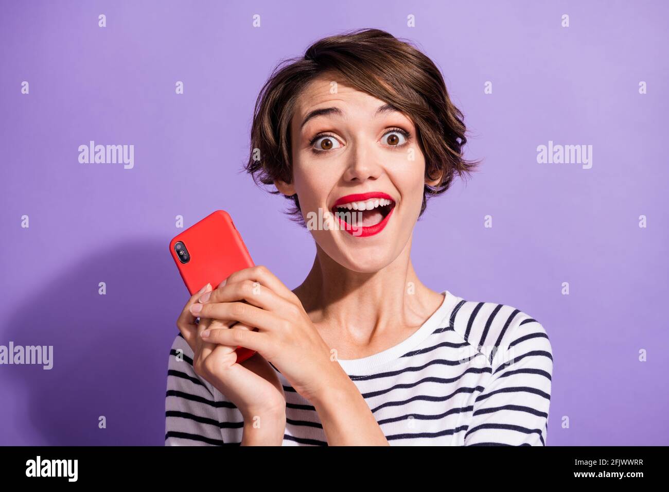 Photo Of Excited Crazy Girl Hold Telephone Look Camera Open Mouth Wear