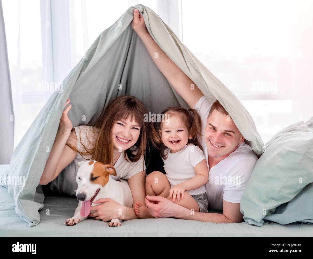 Family under the blanket in the bed Stock Photo - Alamy