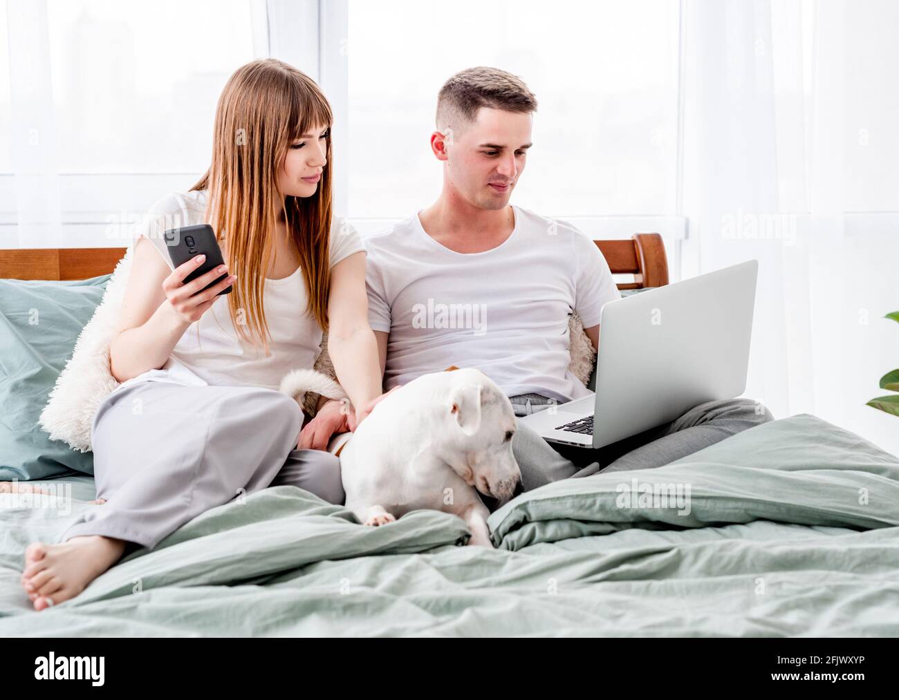 Couple in the bed with gadgets Stock Photo - Alamy