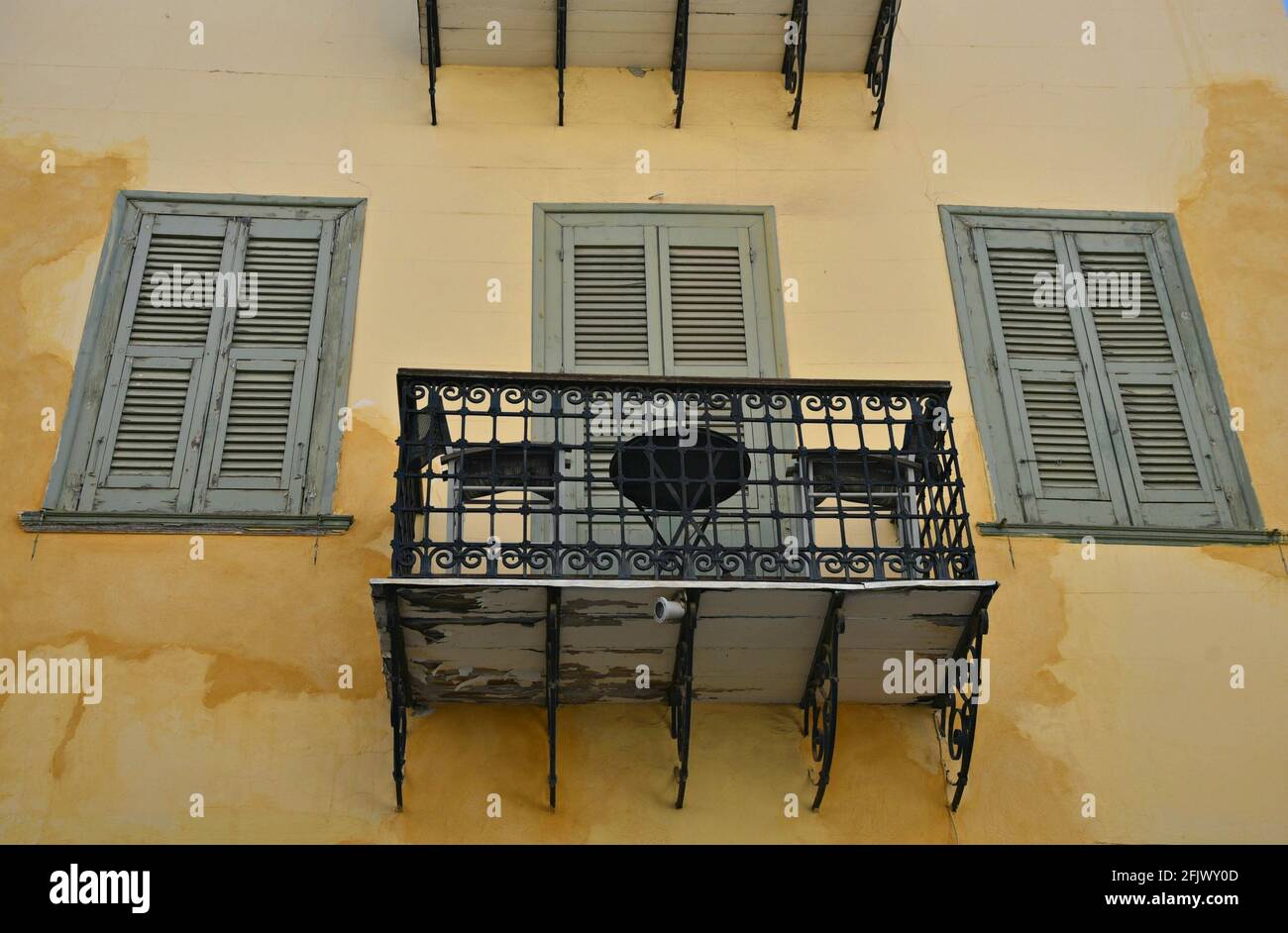Neoclassical house facade with an ochre stucco wall, olive green wooden ...
