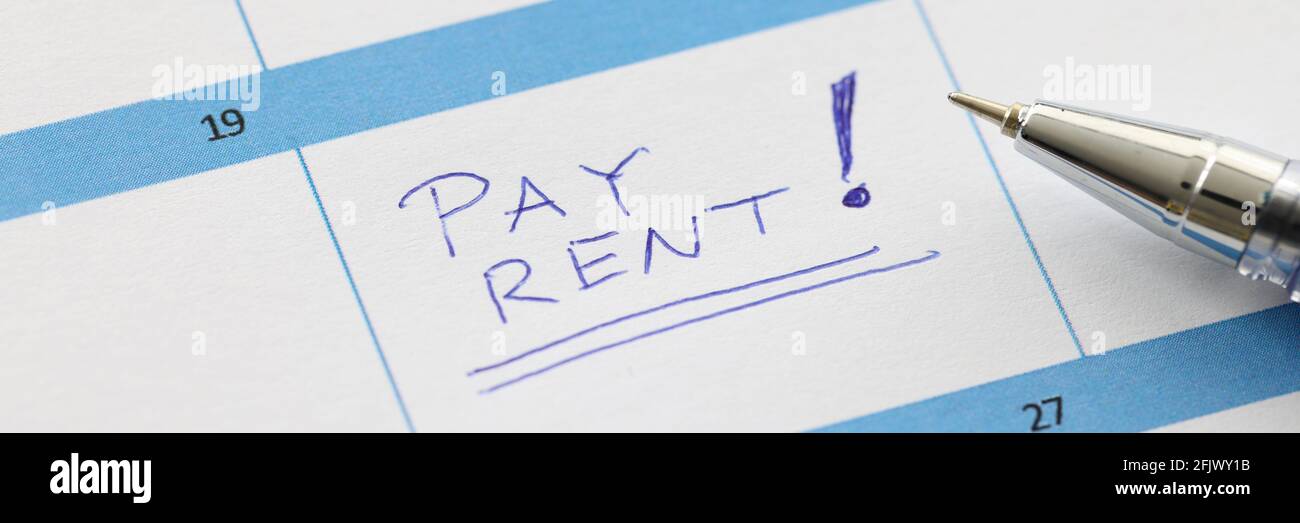 Pay rent is written on sheet of calendar with ballpoint pen closeup ...