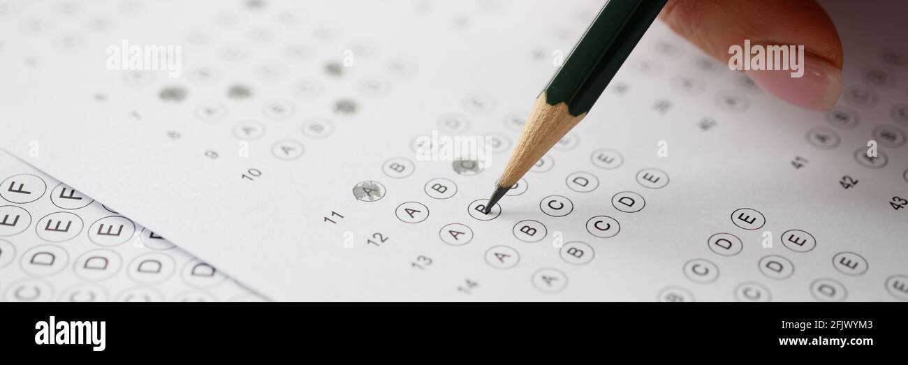 Woman solving tests and writing in pencil on paper closeup Stock Photo ...