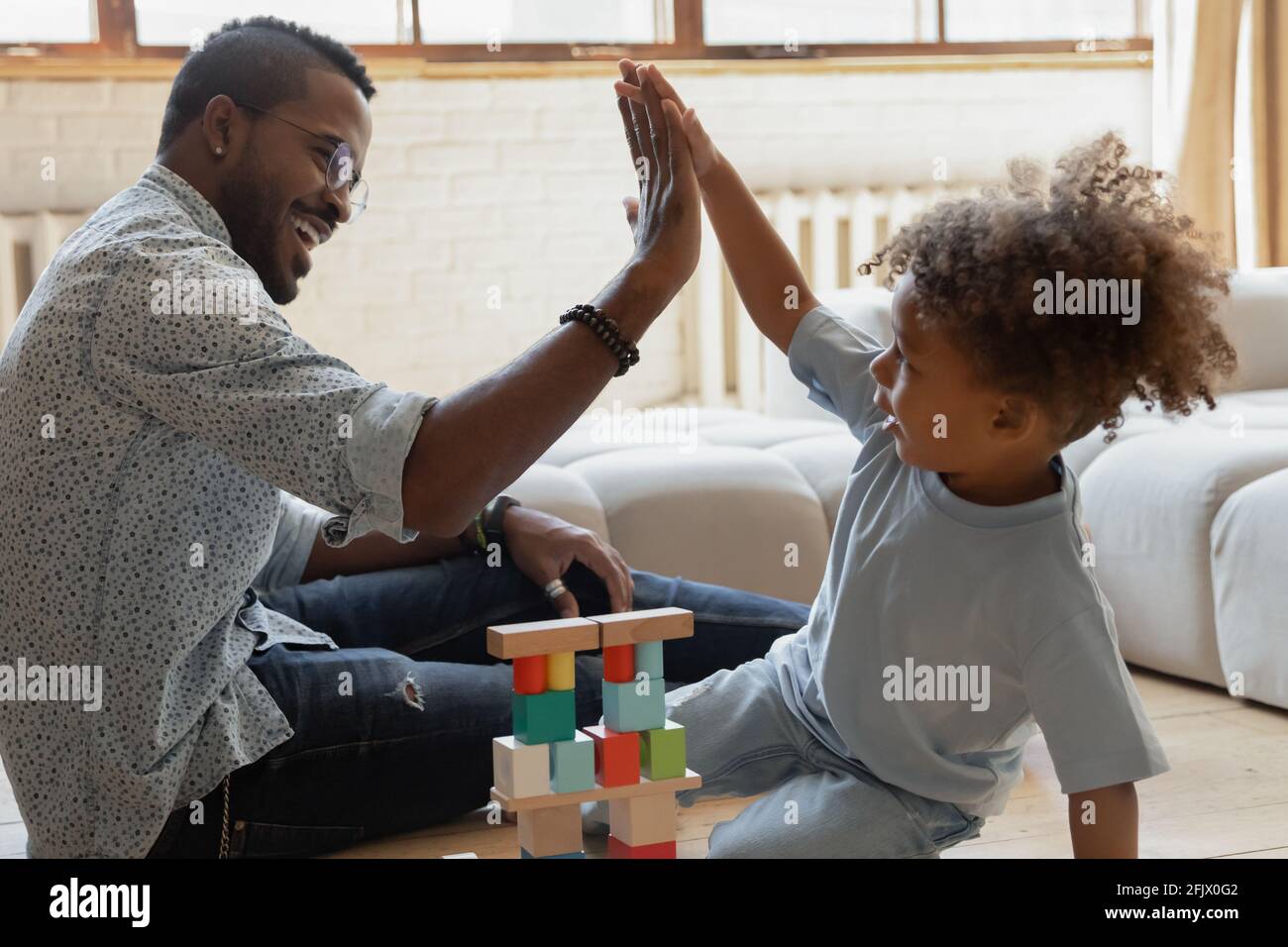 Happy millennial dad giving high five to toddler son Stock Photo - Alamy
