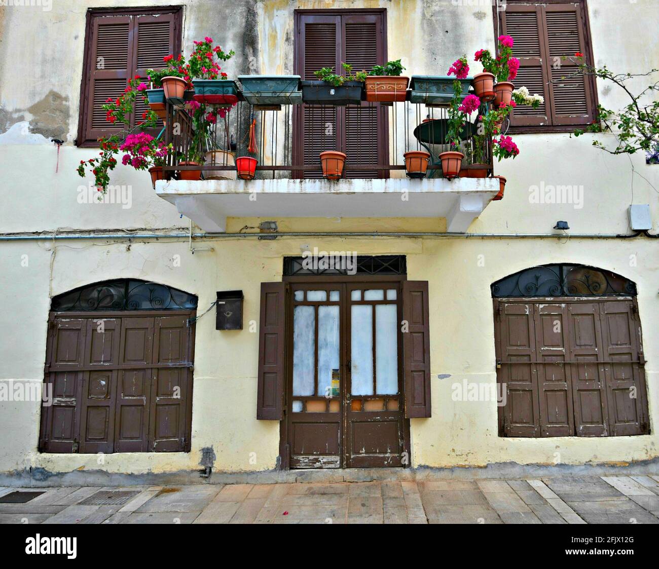 Neoclassical house facade with wooden door and shutters and an iron ...