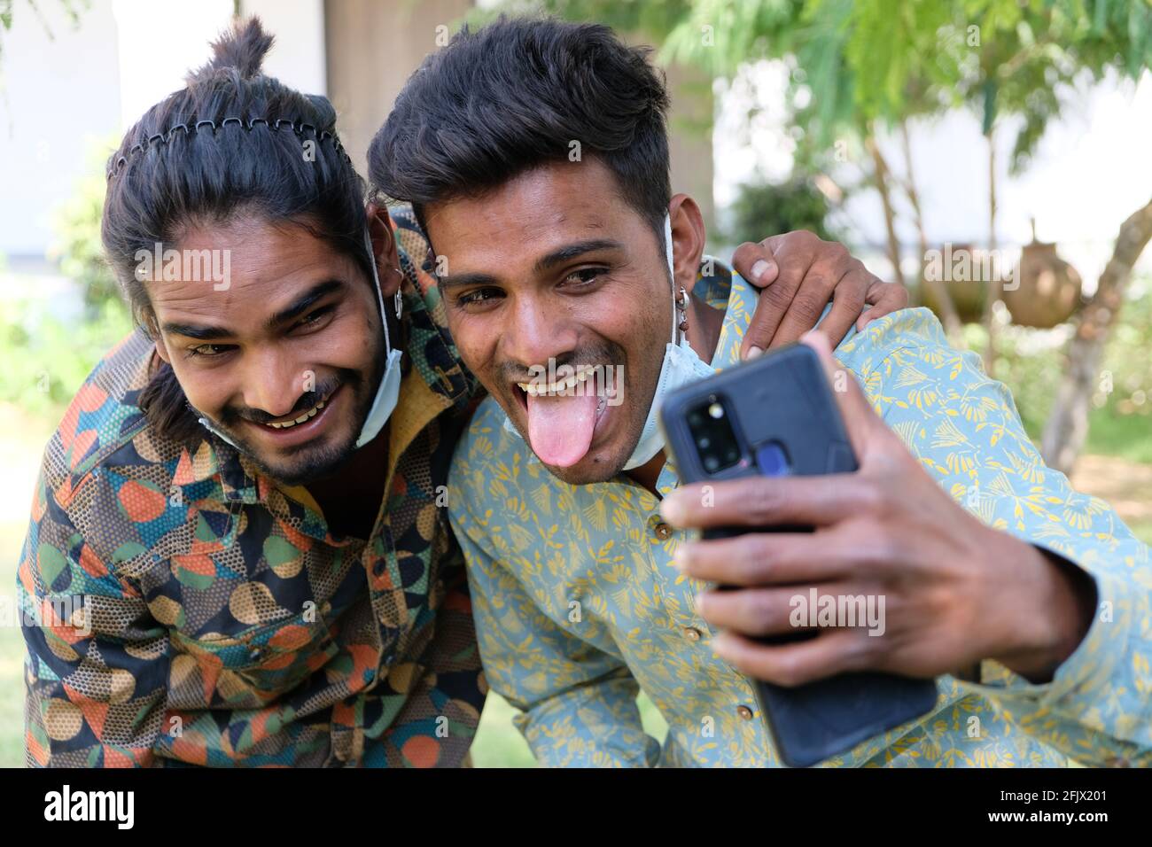 Portrait of two happy Indian friends doing a selfie in the park Stock ...