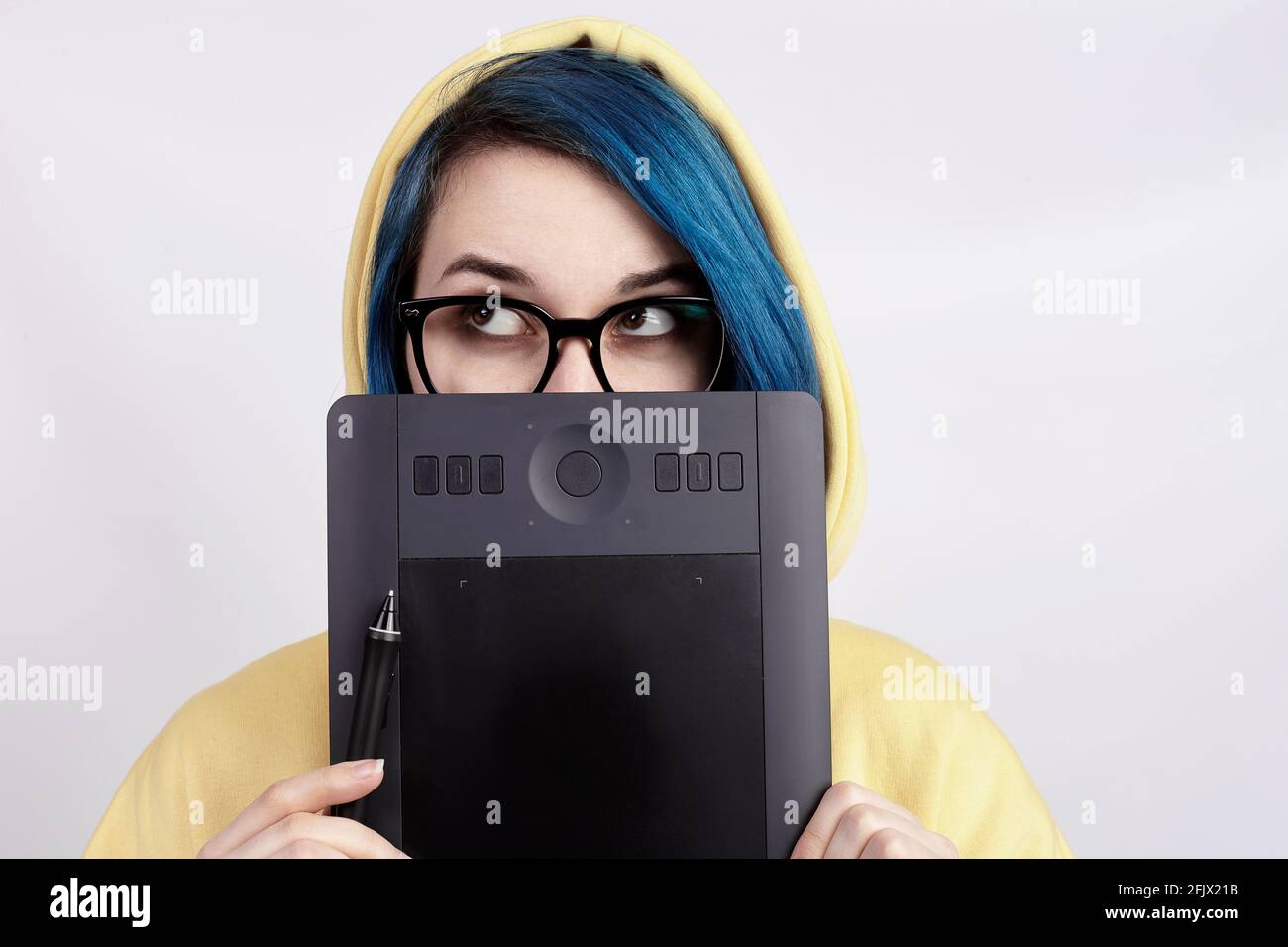 A female designer in yellow hoody holding graphic tablet. The white ...