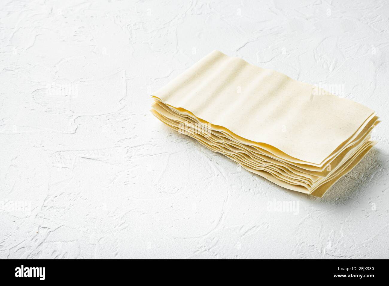 Dried uncooked lasagna pasta sheets set, on white stone background ...