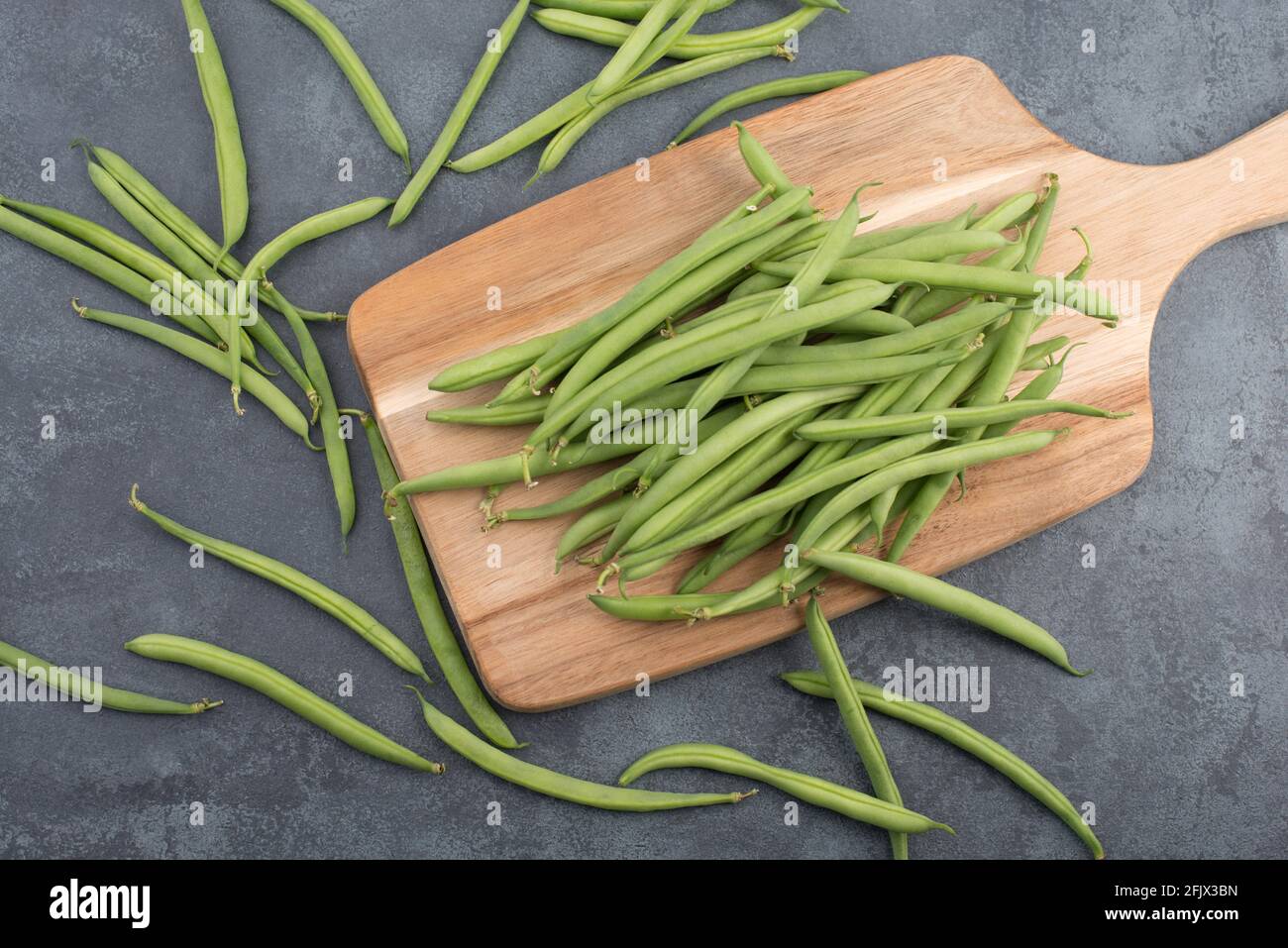 Green string beans on a textured background, empty space for text ...