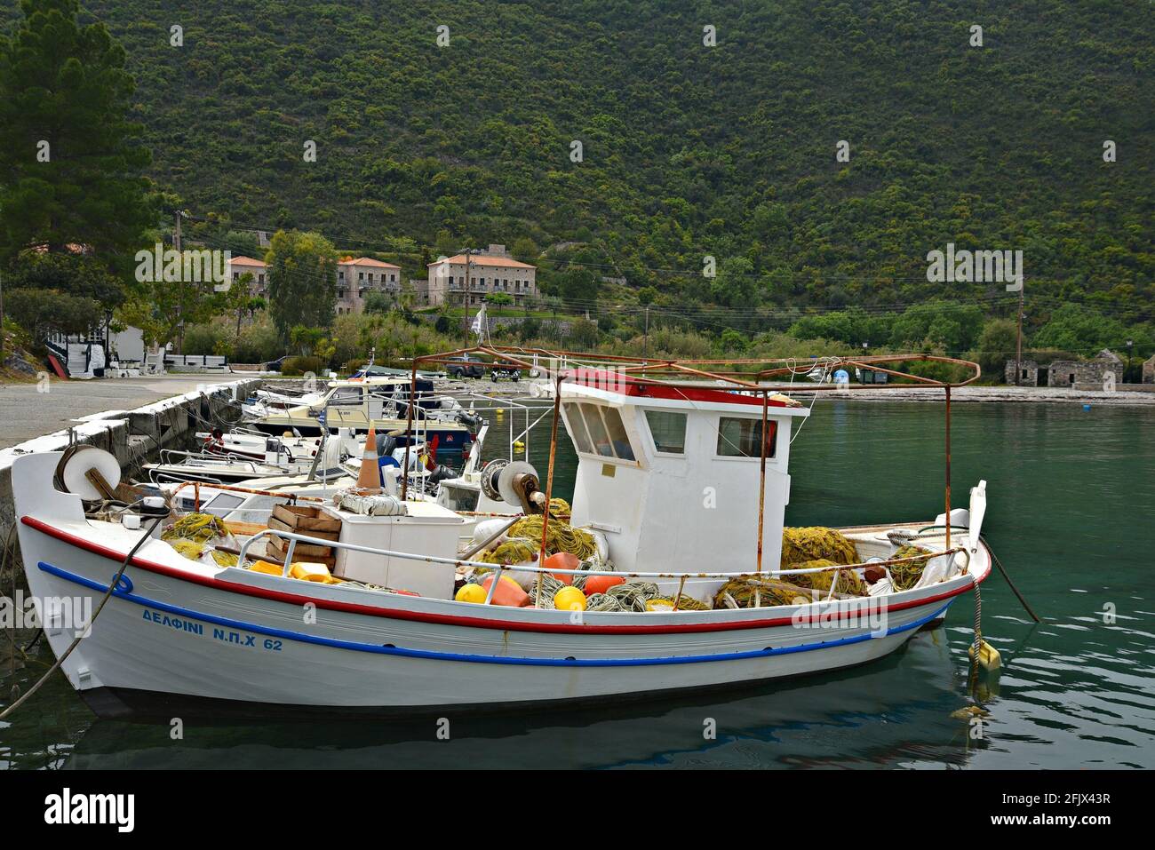 Port view, traditional Greek fishing boats and rural stone houses in ...