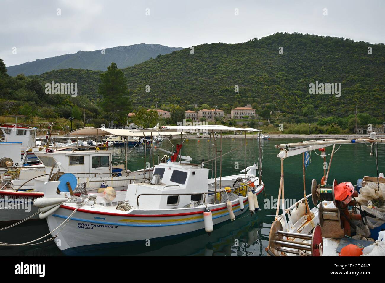 Port view, traditional Greek fishing boats and rural stone houses in ...
