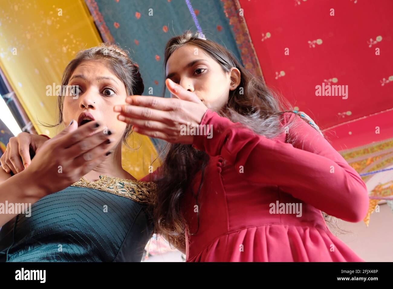 Low angle shot of two female South Asian friends in traditional dresses ...